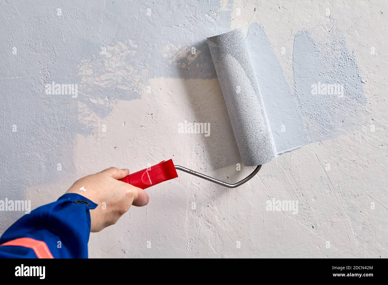 Coloring walls at home using paint roller by repairman Stock Photo - Alamy