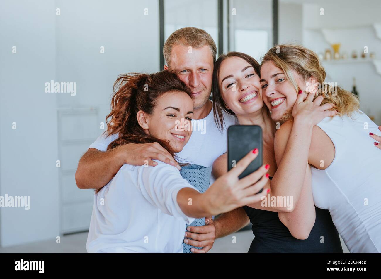 Smiling young people having fun making selfie photo after yoga class ...