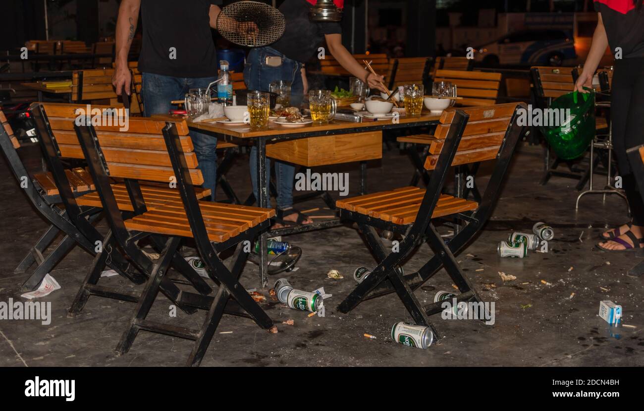 Mess after dinner in Vietnam restaurant in dark evening with waiters ...