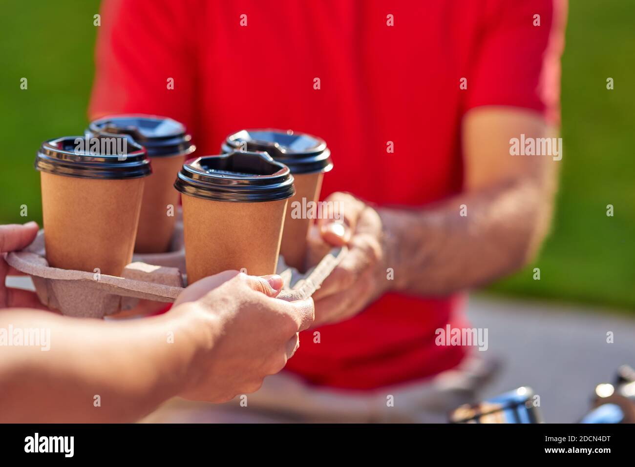 Male courier delivering four coffee cups by scooter. Food delivery ...