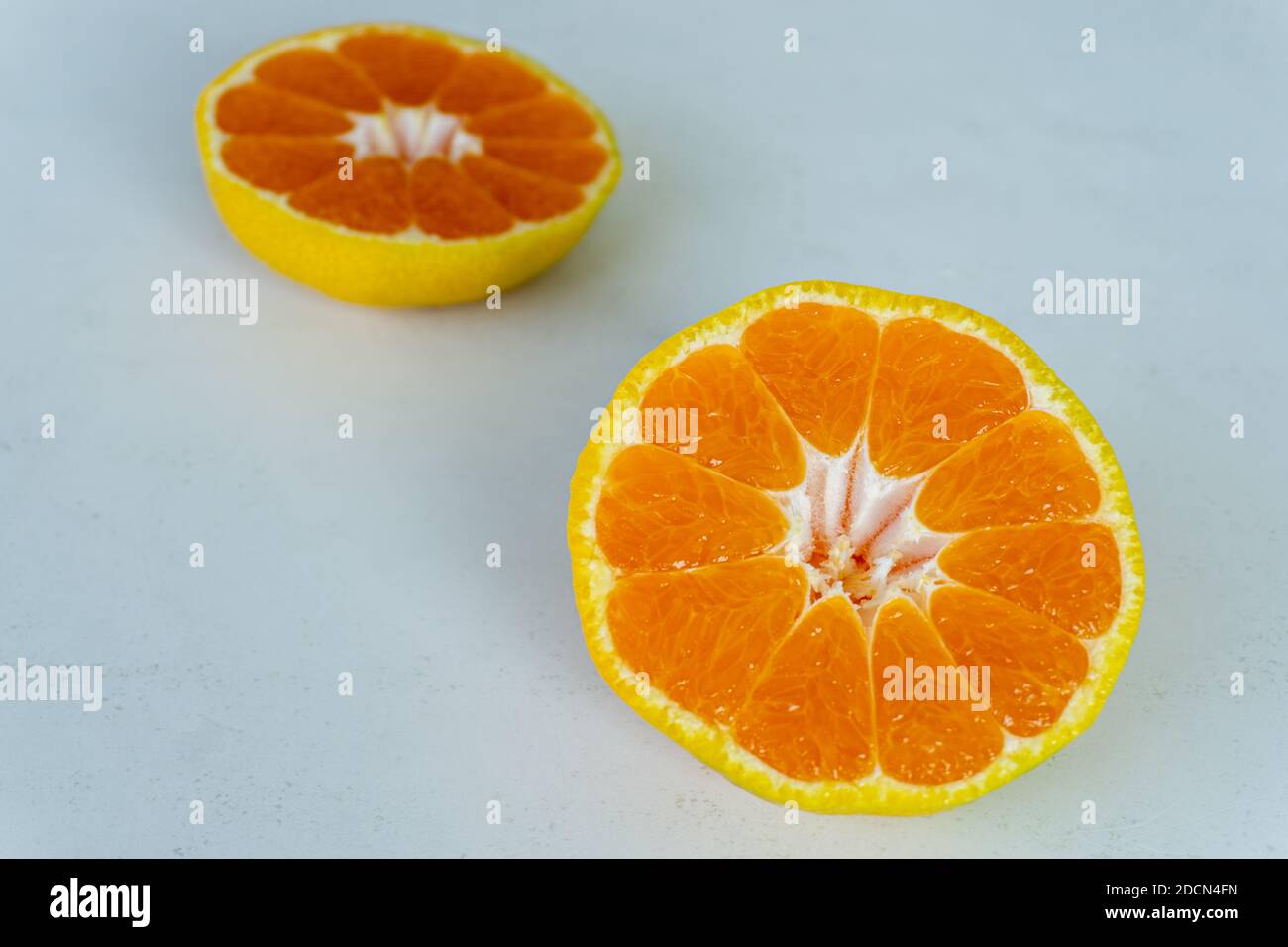 Tangerine cut in half on a white background Stock Photo - Alamy