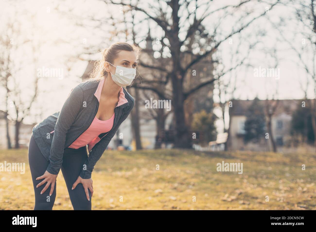 Fit woman during covid-19 crisis having break from running Stock Photo ...