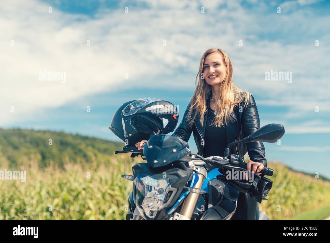 Beautiful woman on a motorcycle looking at the road ahead Stock Photo ...