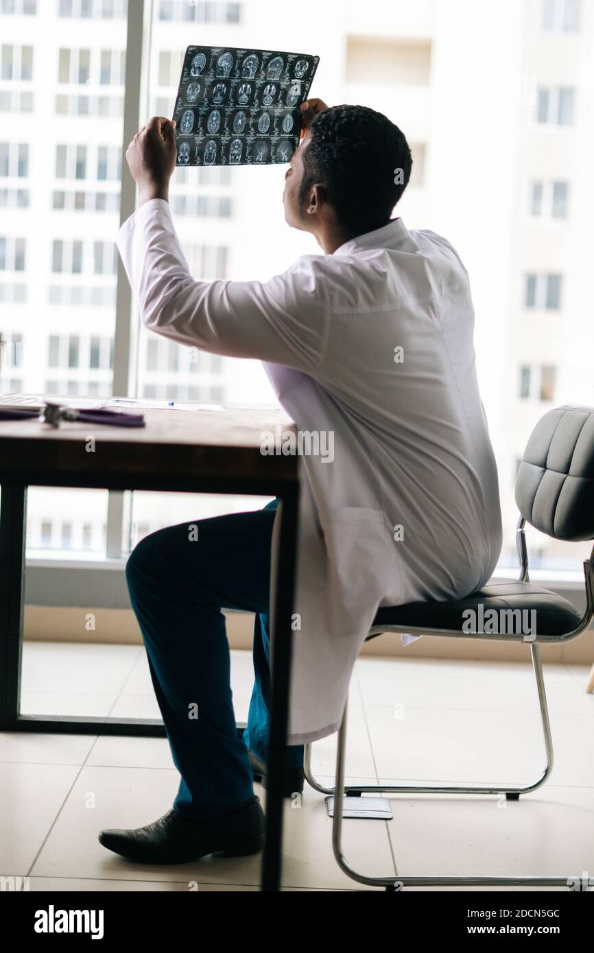 African American black man doctor looking at MRI brain scan image while ...