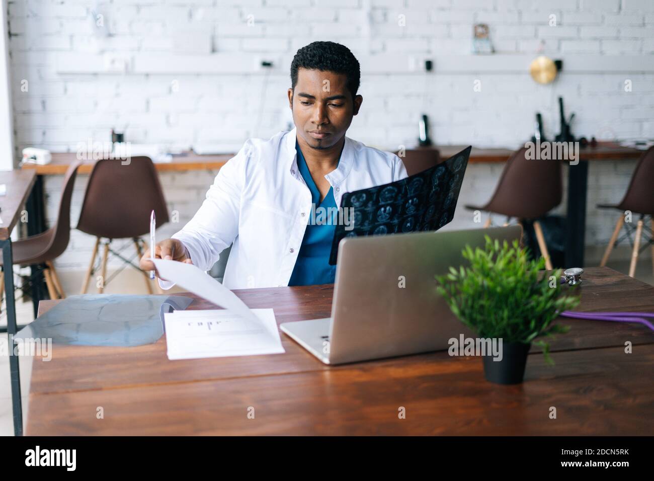 African American black man doctor looking at MRI brain scan image while ...