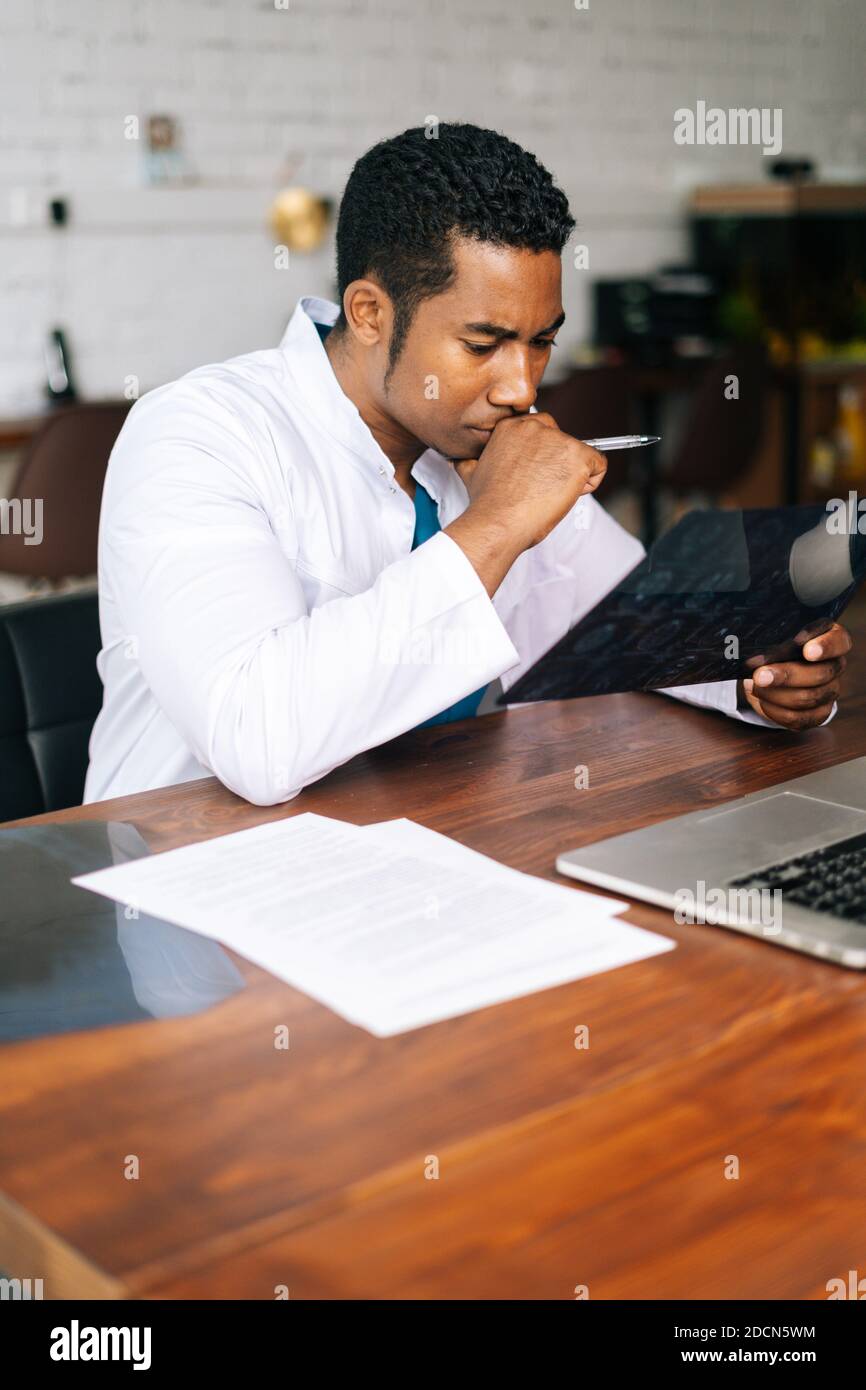 African American black man doctor looking at MRI brain scan image while ...