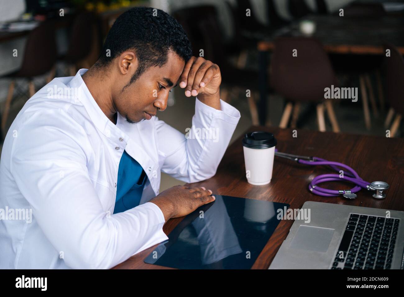 Serious African American black man doctor working typing on laptop ...
