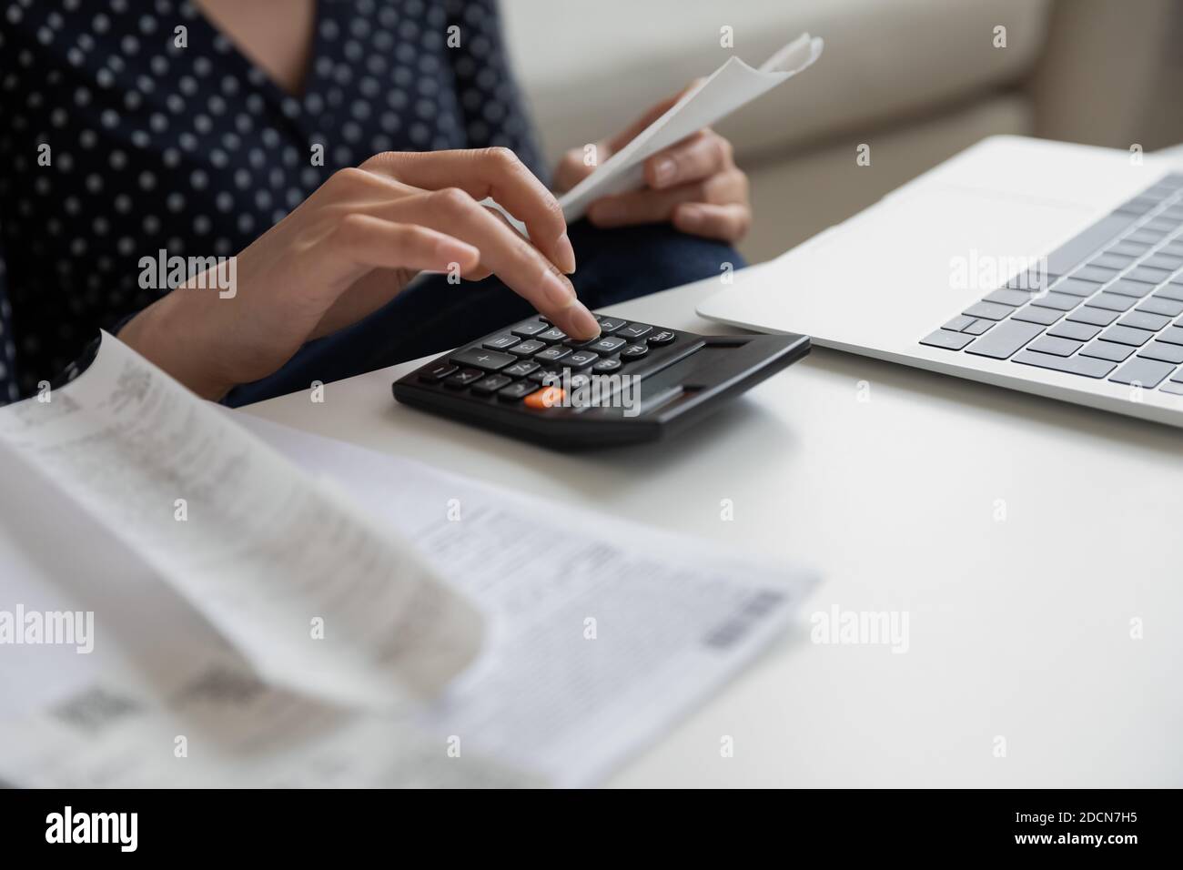 Close up woman calculating bills, using calculator, holding receipt ...