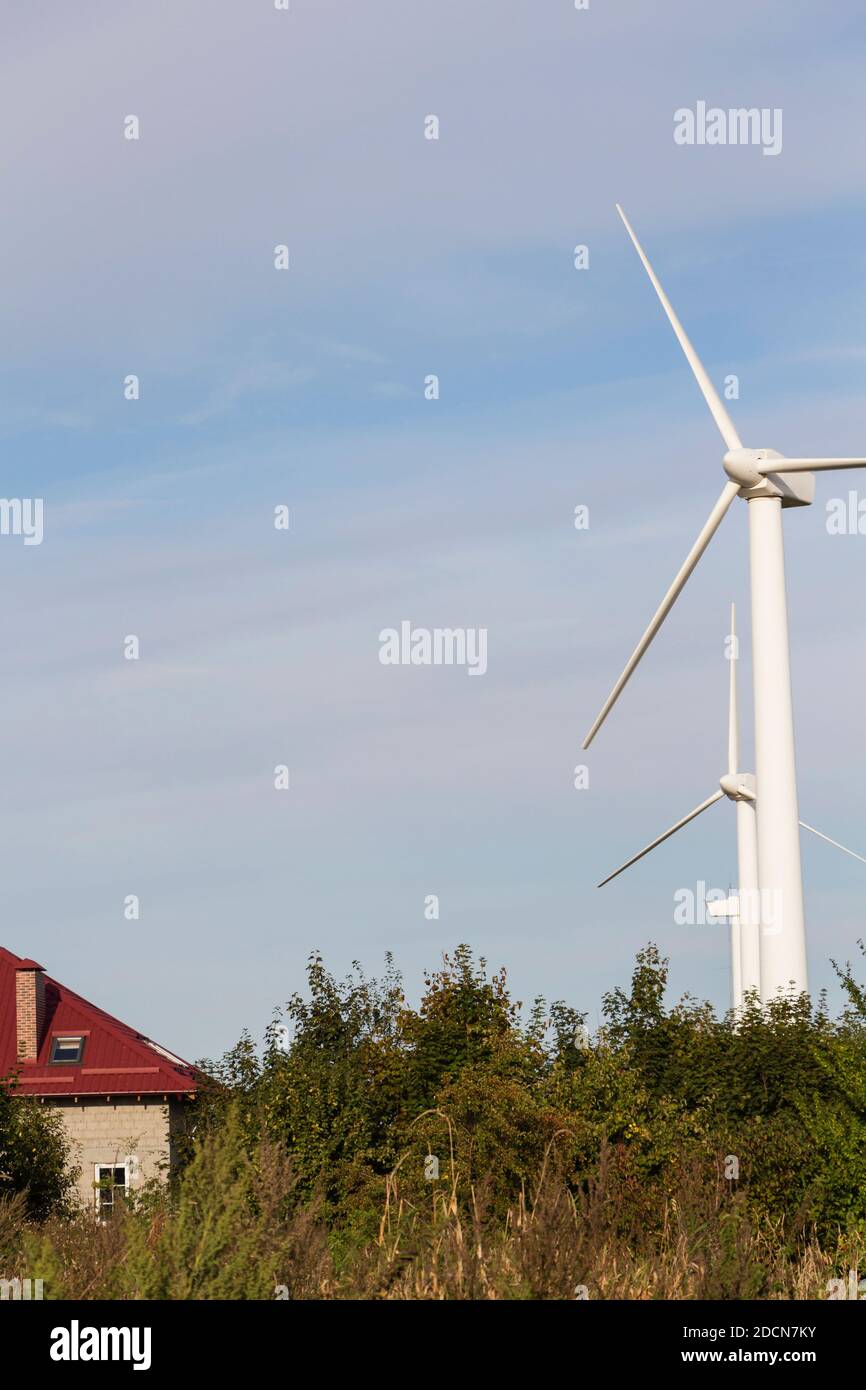 Windmill for electricity among the trees with the house Stock Photo - Alamy