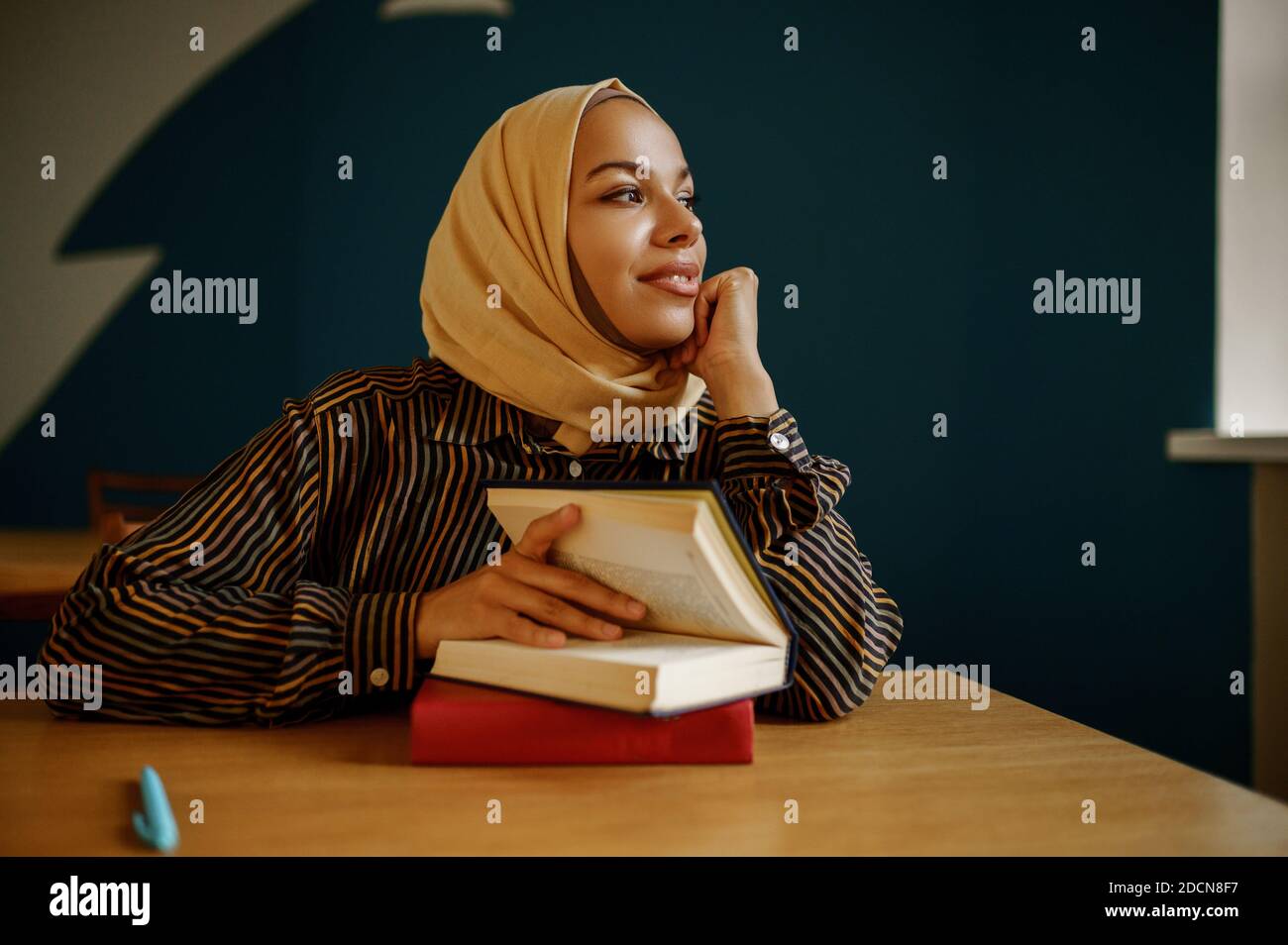 Arab female student in hijab holds textbook Stock Photo - Alamy