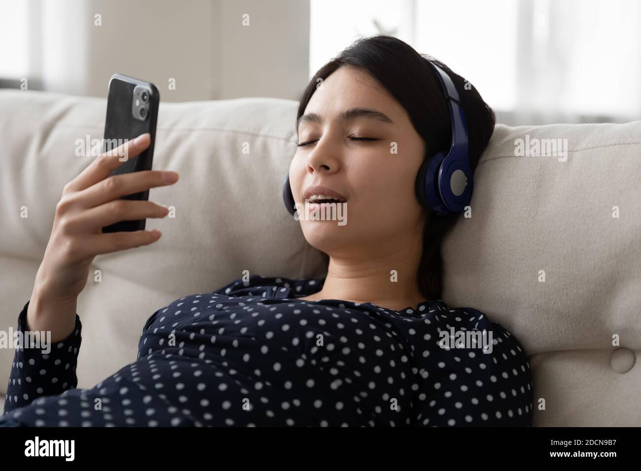 Close Up Happy Asian Young Woman Wearing Headphones Using Phone Stock