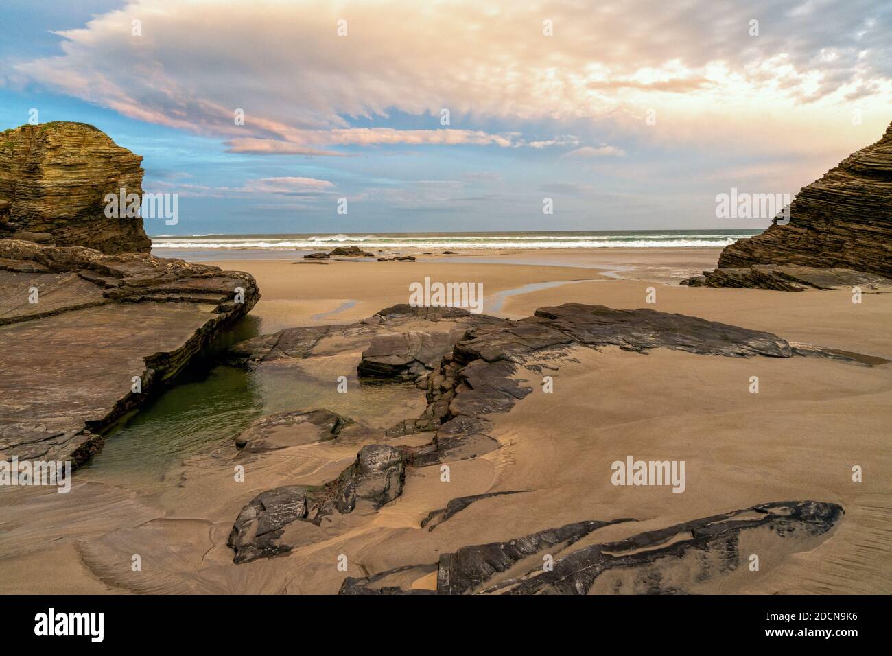 A beautiful beach with fine sand and rocky cliffs at sunrise Stock ...
