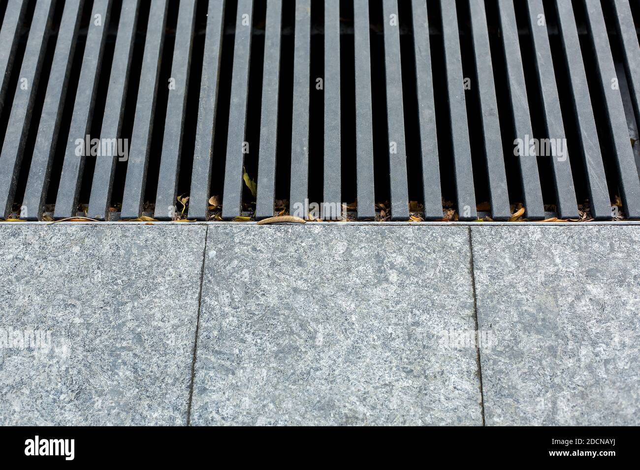 grating of the drainage storm system on the pedestrian park sidewalk ...