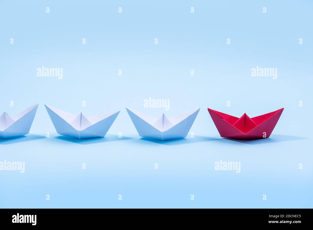 Red and white paper boats. Concept of leadership boats for teamwork ...