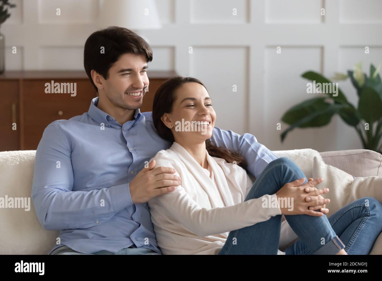 Happy millennial family sitting on couch on cozy hi-res stock ...