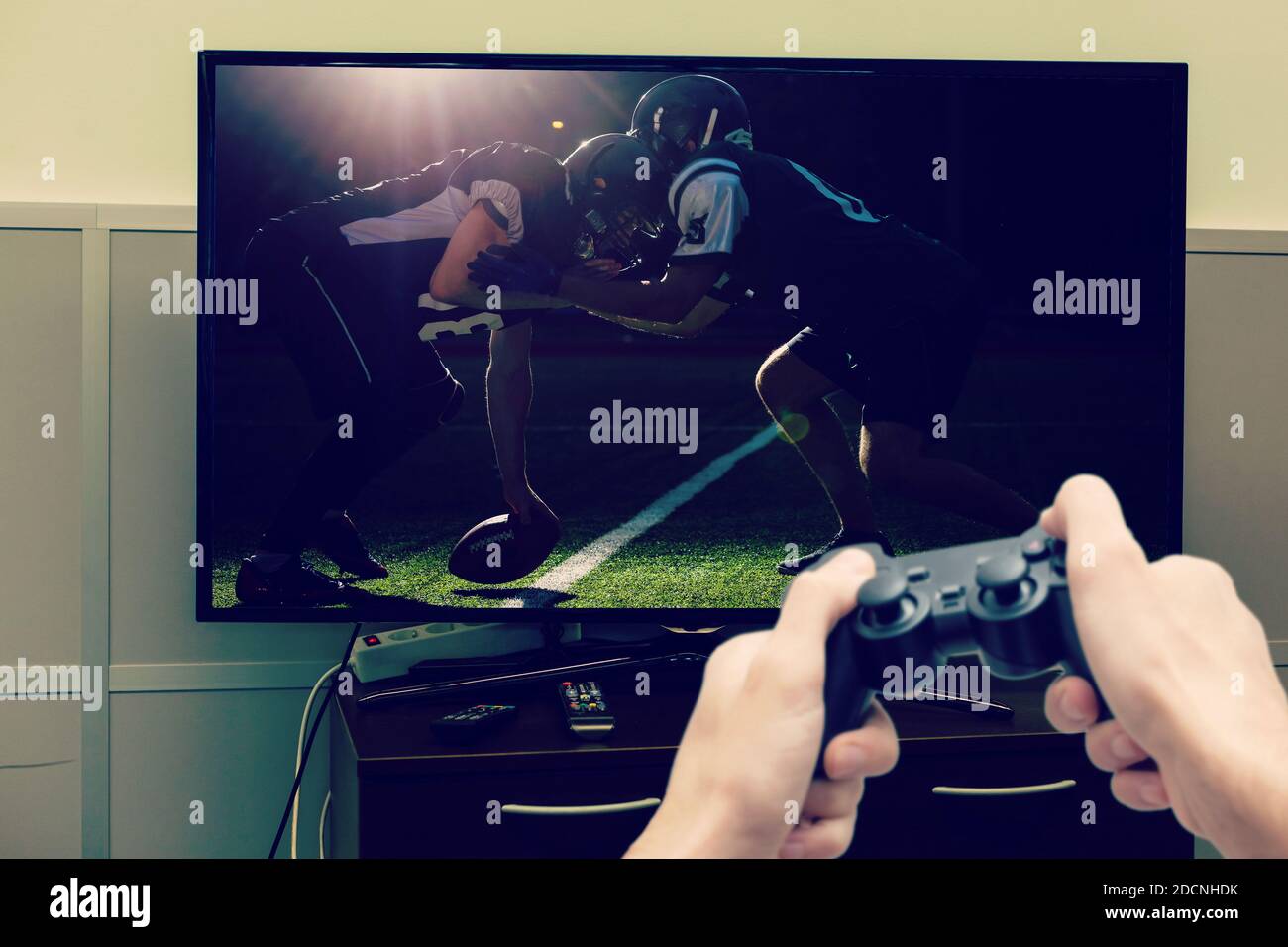 Man playing video game. Hands holding console controller. Football or ...