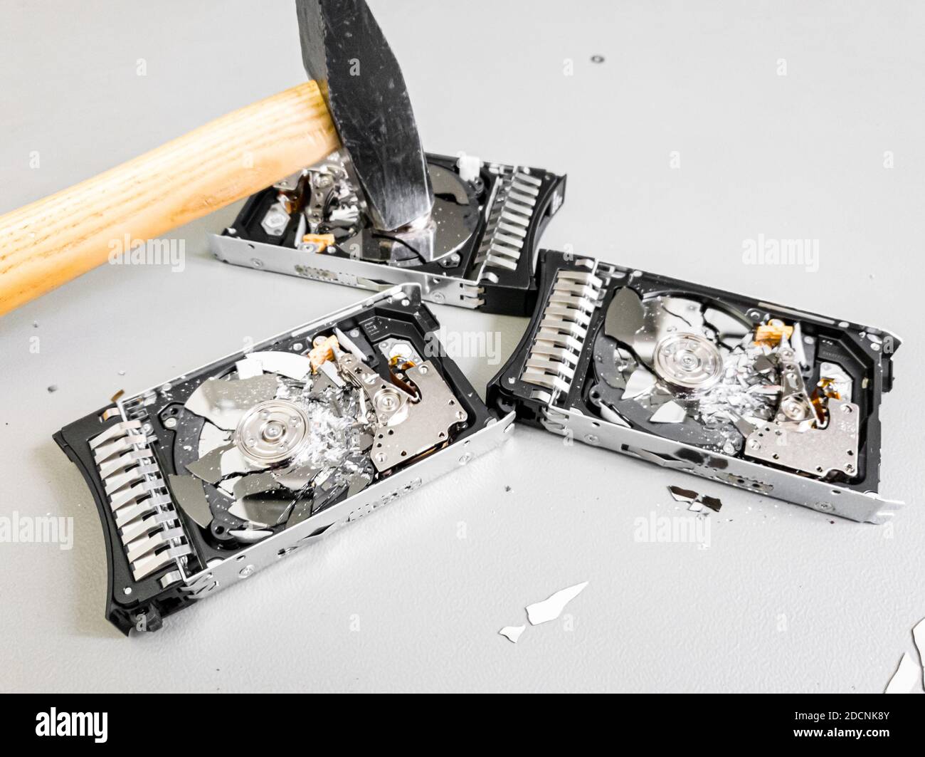 Three hard disk drives with shattered platter on a table Stock Photo ...