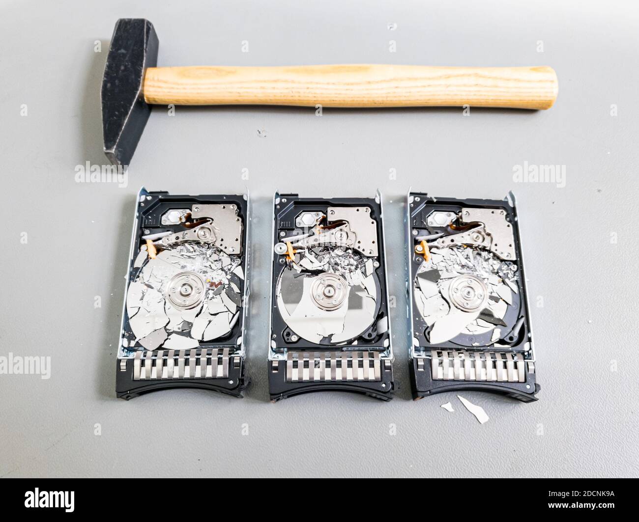 Three hard disk drives with shattered platter on a table Stock Photo ...