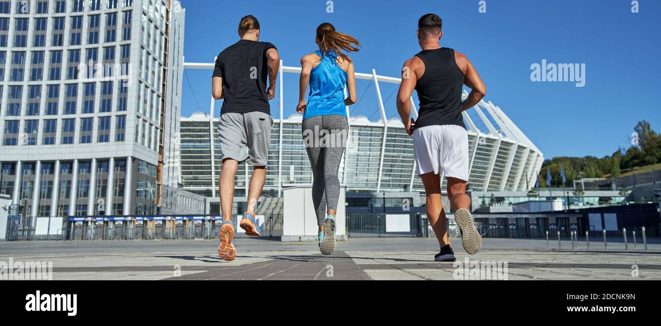 Young people in sportive clothes running to stadium Stock Photo - Alamy