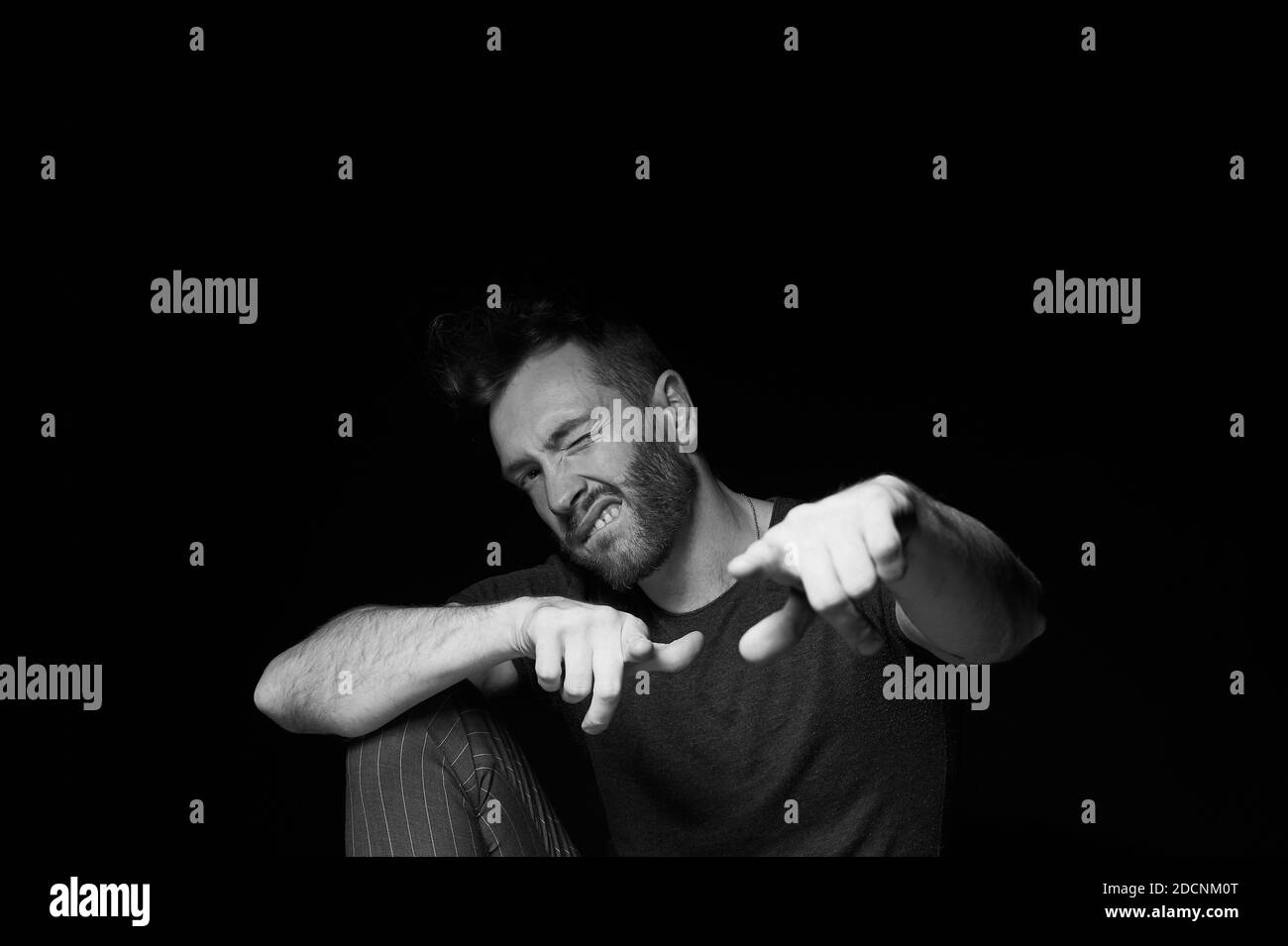 A man on a dark background.A cheeky pose. You deserve it Stock Photo ...