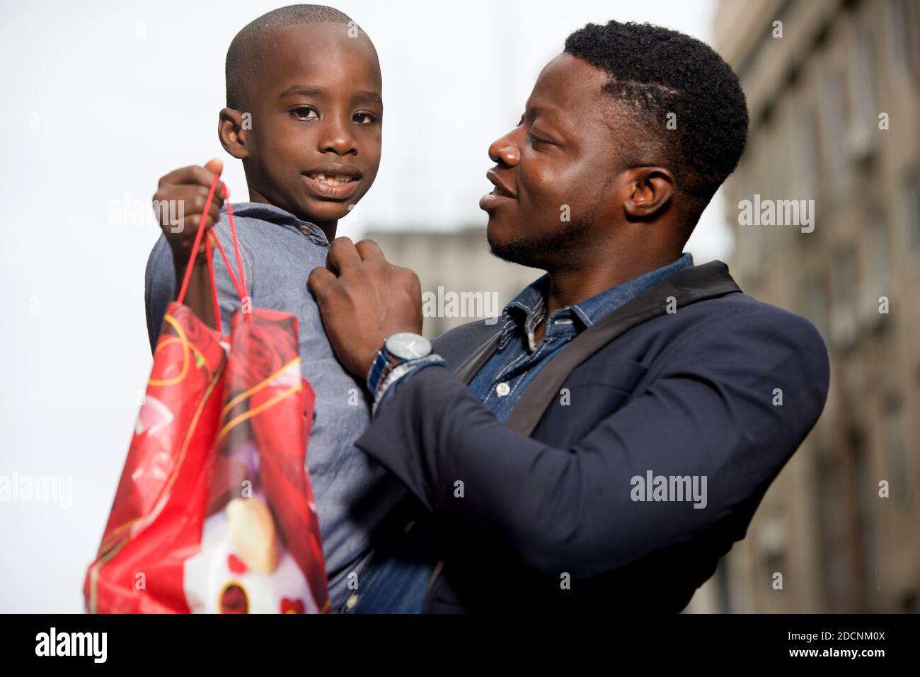 young man standing in a suit looking at his child smiling Stock Photo ...