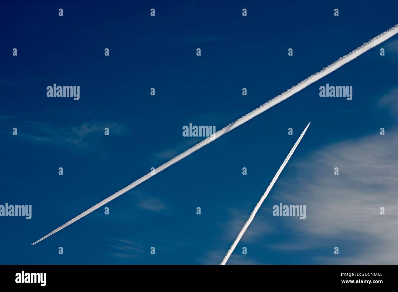 Jet contrails crossing each other in a blue sky Stock Photo - Alamy