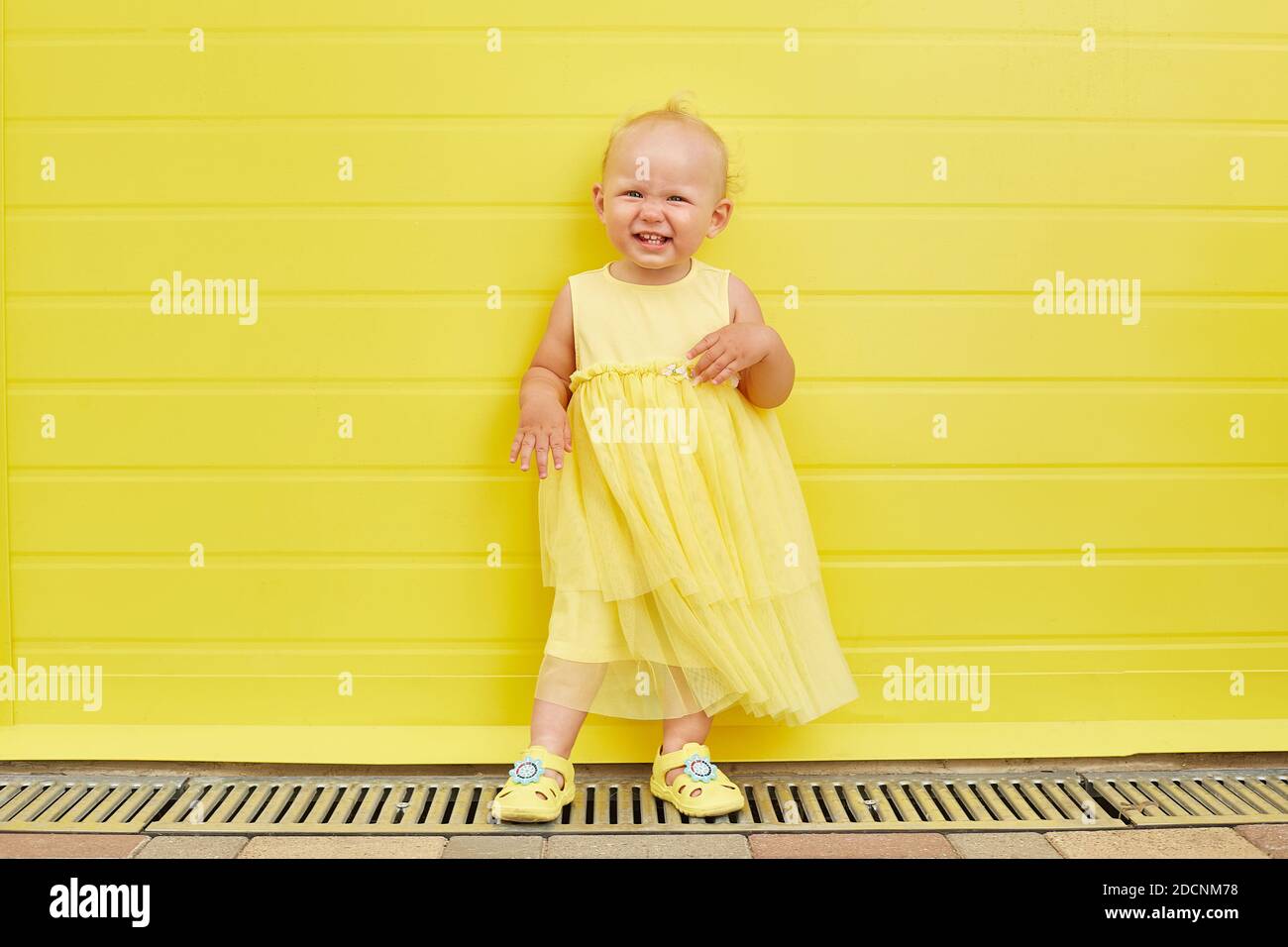 Adorable Little girl smiling on yellow background Stock Photo - Alamy