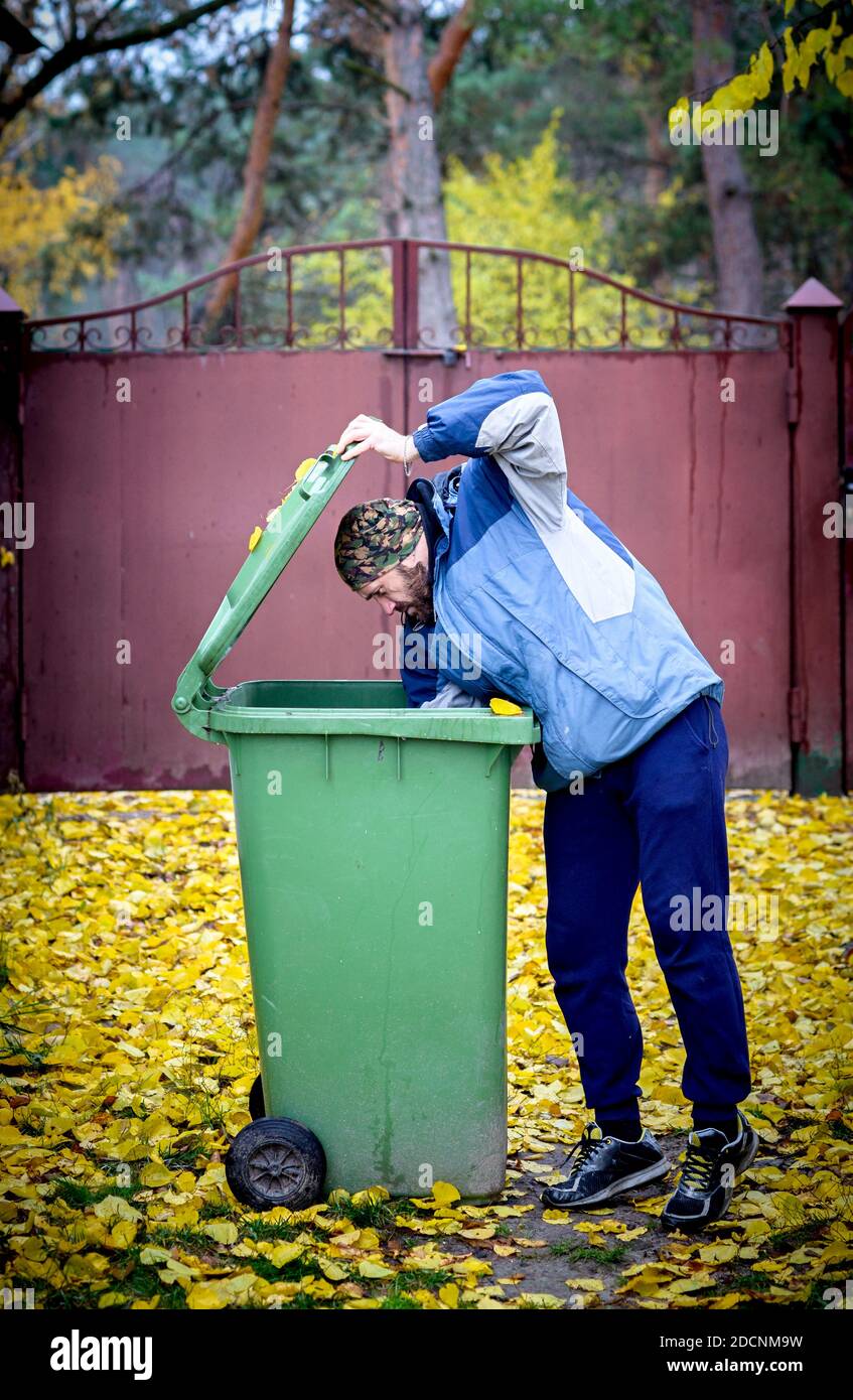 A man digs in a trash can Stock Photo - Alamy