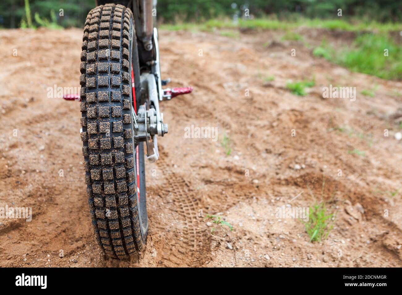 Skid-resistant tread on motorcycle tire, motocross bike in sandy track ...