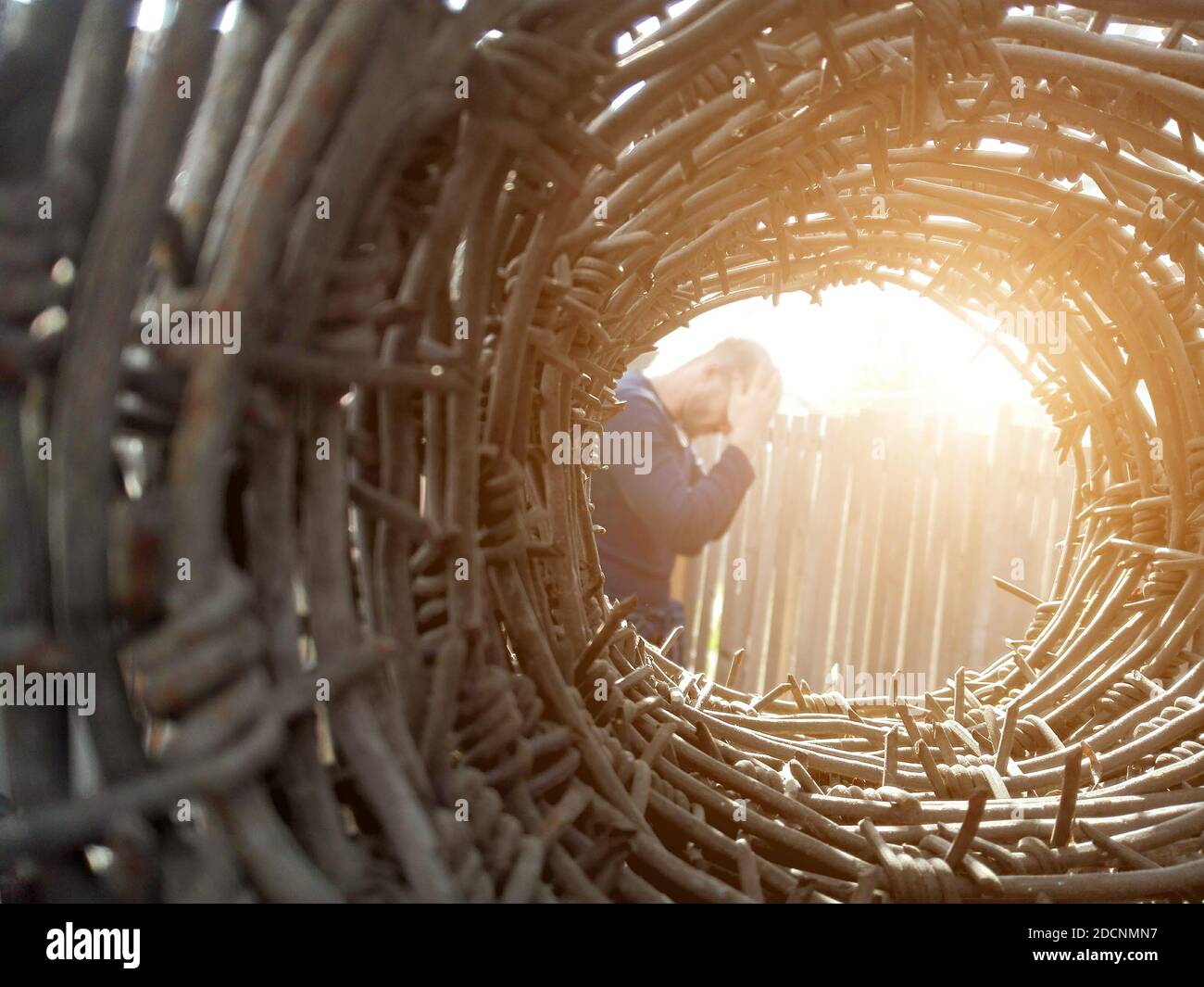 Man behind barbed wire fence hi-res stock photography and images - Alamy