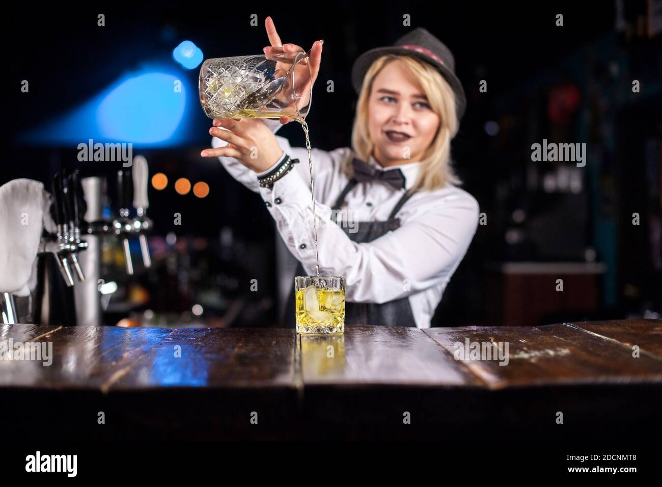 Experienced barmaid creates a cocktail behind bar Stock Photo - Alamy