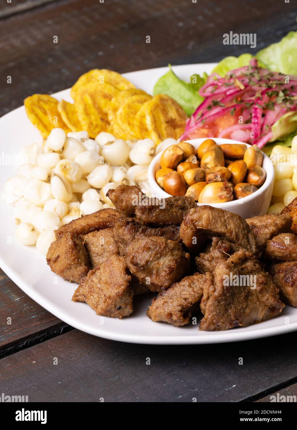 A vertical shot of fried chicken with corn kernels banana chips and ...