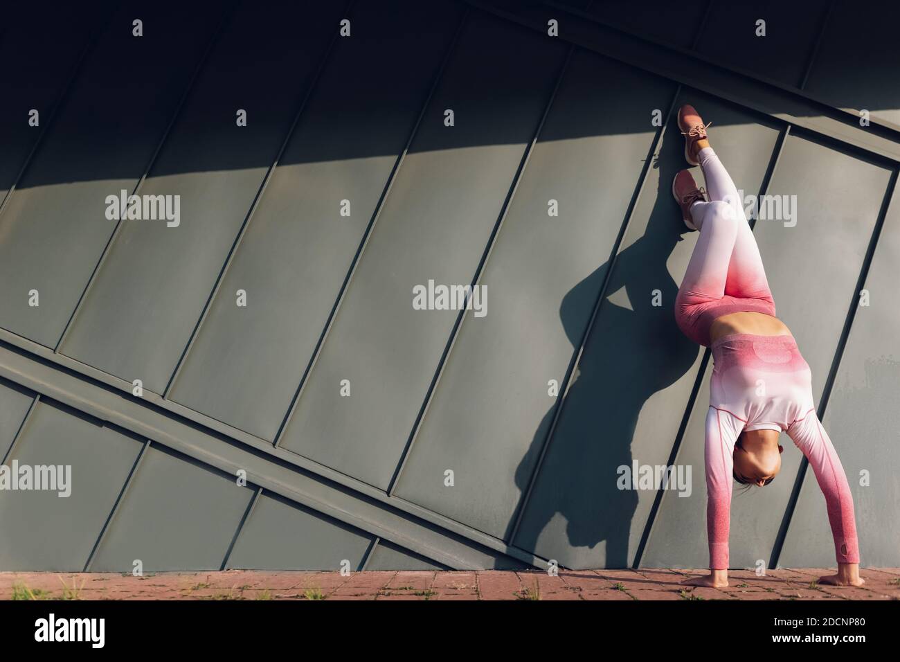 Athetic girl doing handstand against the wall on the street Stock Photo ...