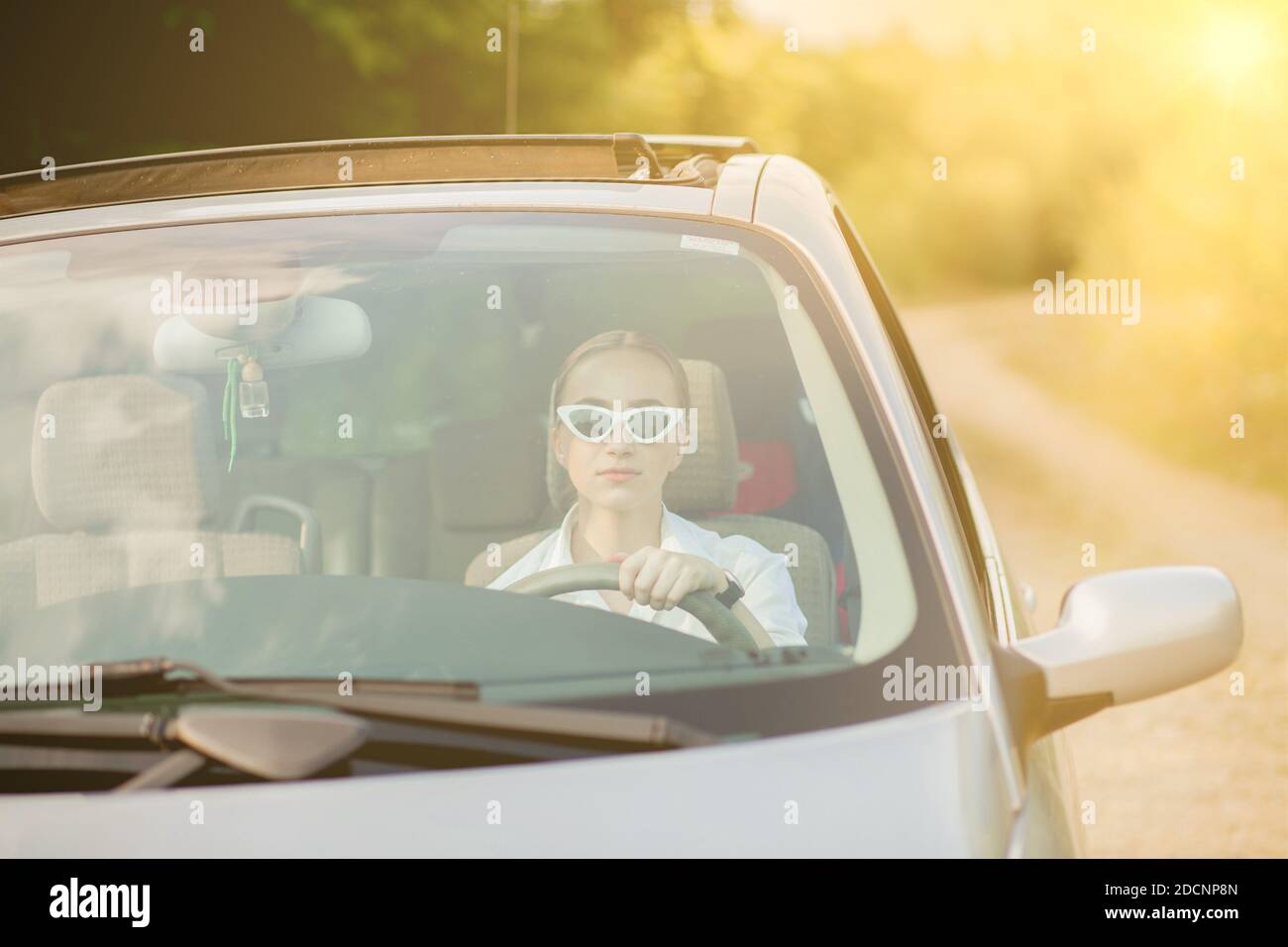Portrait shot through windshield of pretty woman in car Stock Photo - Alamy