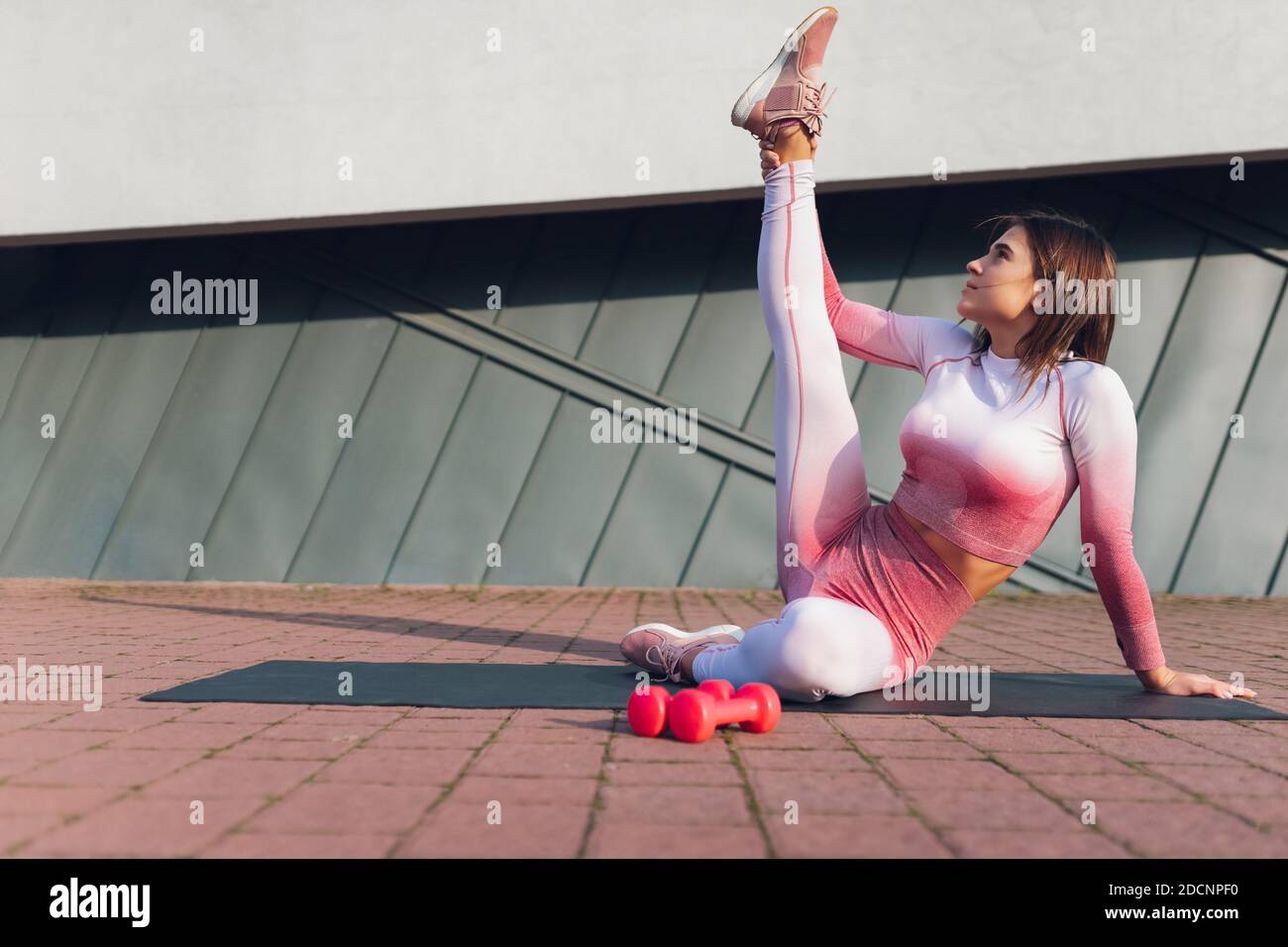 Slender girl doing flexibility exercises. Stretching on yoga mat Stock ...