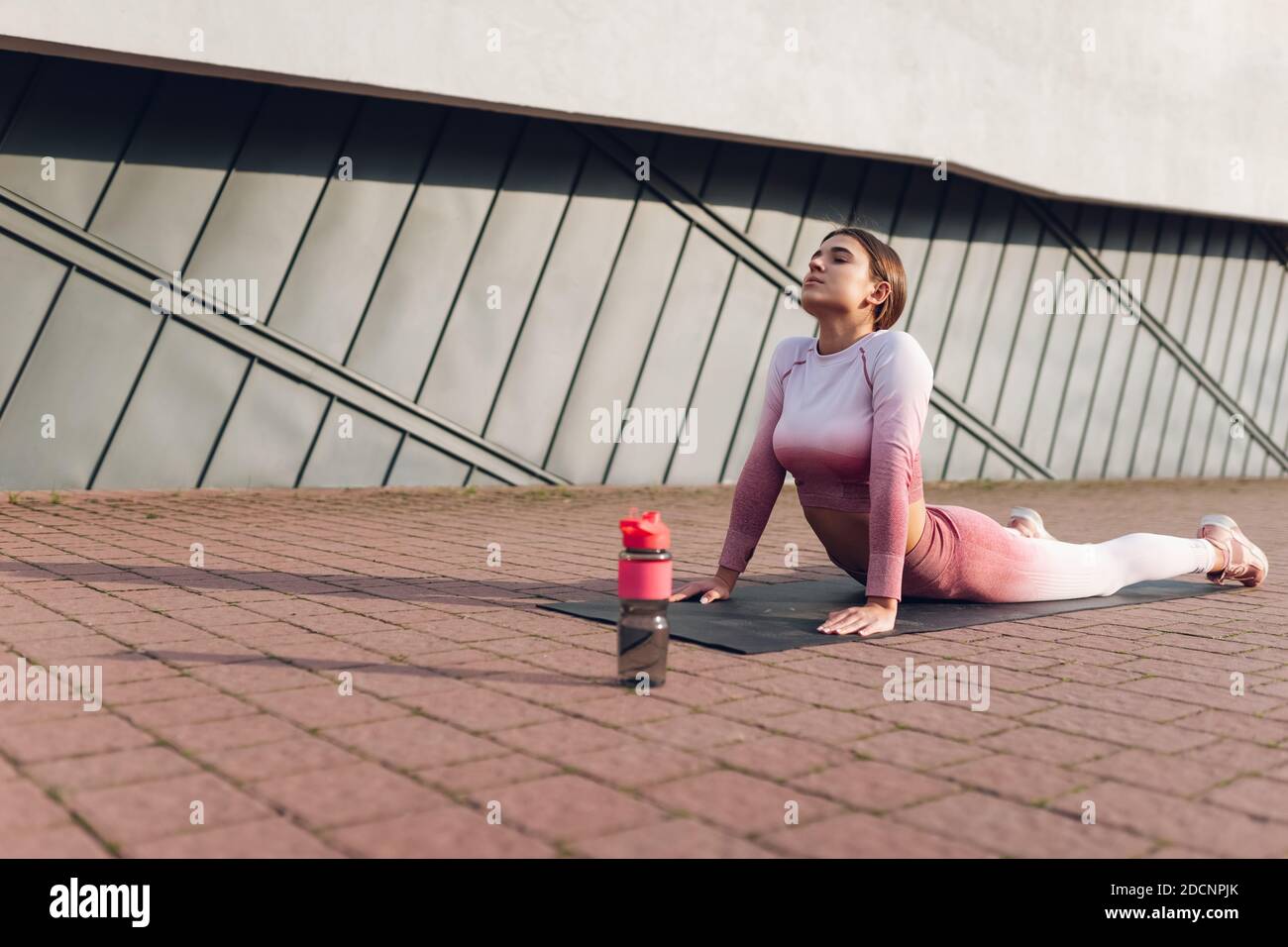 Sportswoman stands in cobra stretch exercise pose Stock Photo - Alamy