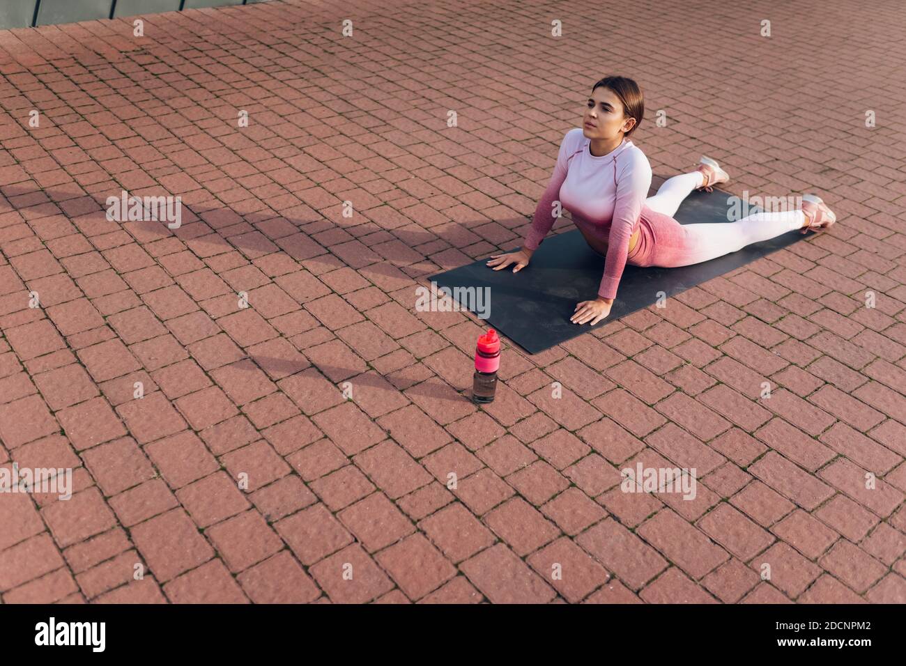 Sportswoman stands in cobra stretch exercise pose Stock Photo - Alamy