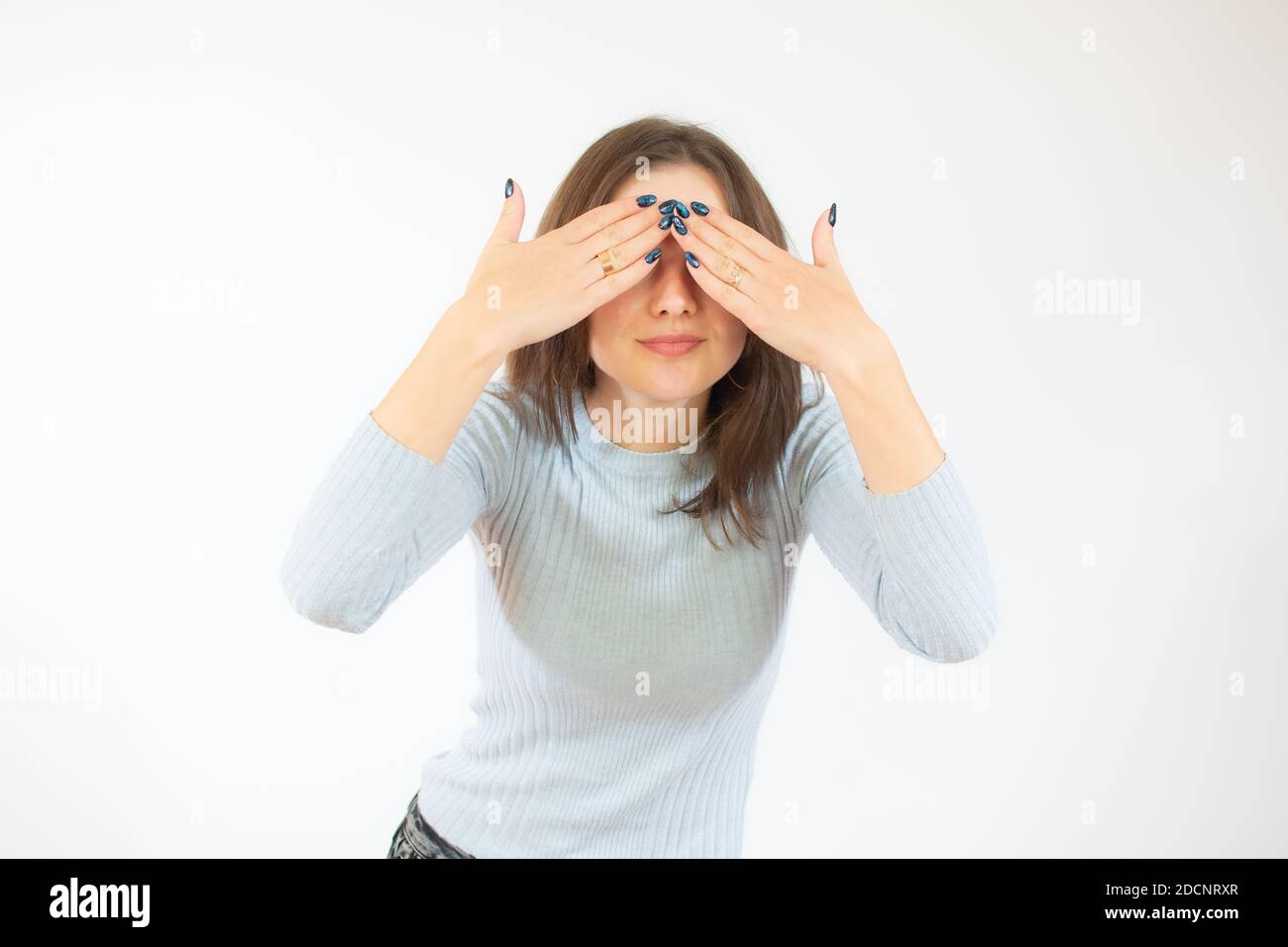 Young woman covering her eyes with her hands.Studio shot Stock Photo ...