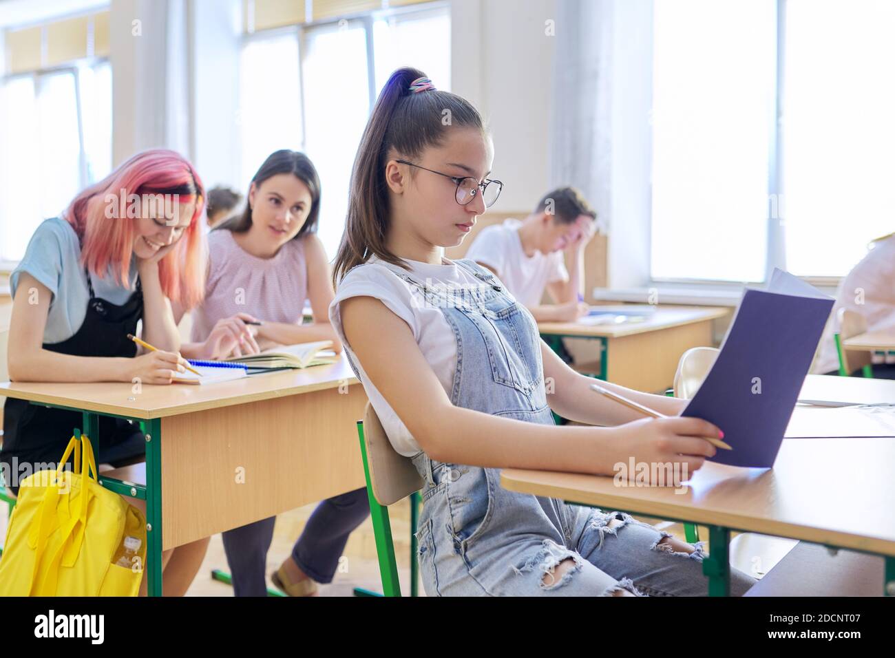 Lesson in class of teenage children, in front girl 13, 14 years old ...