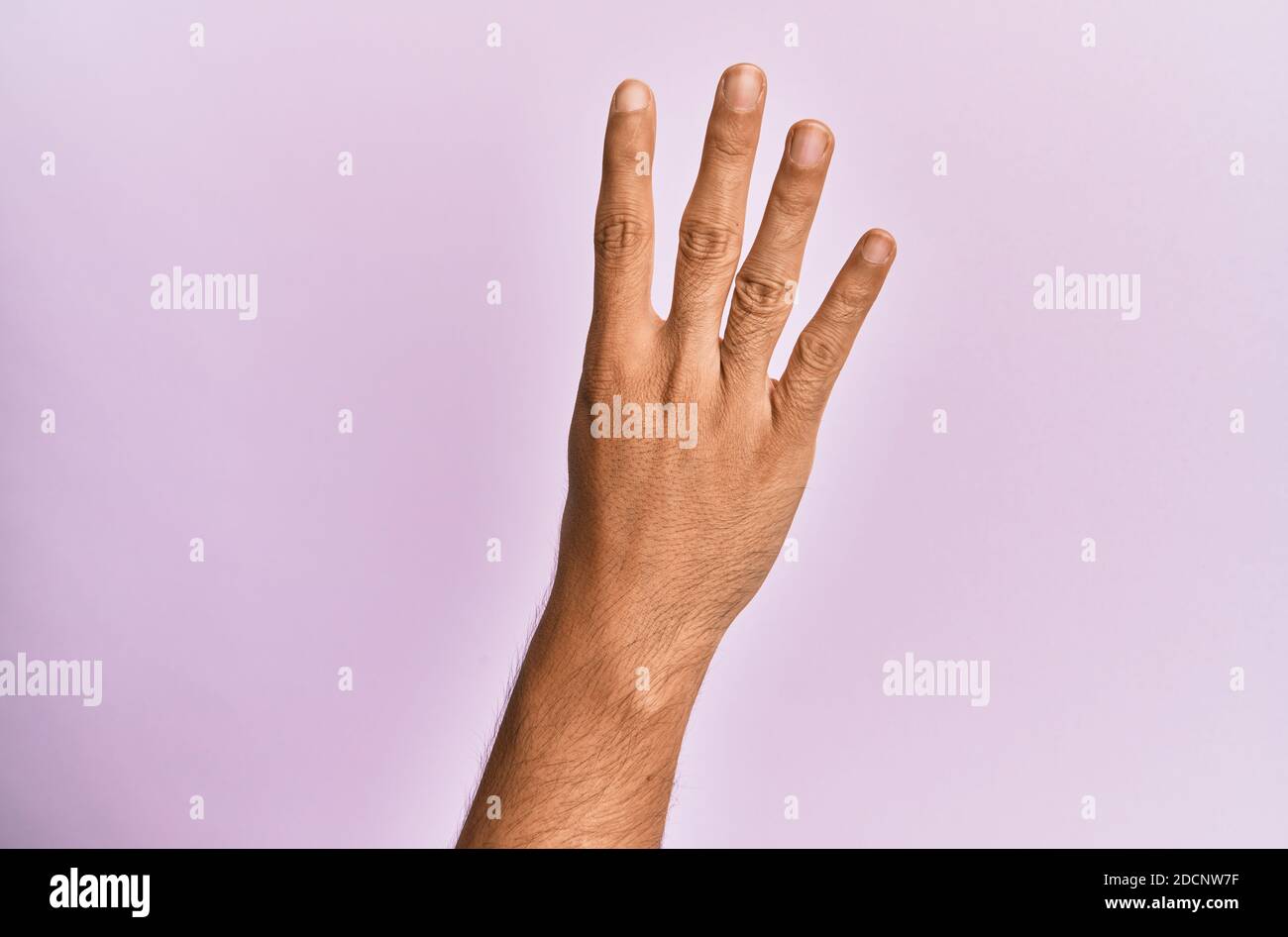 Arm and hand of caucasian young man over pink isolated background ...