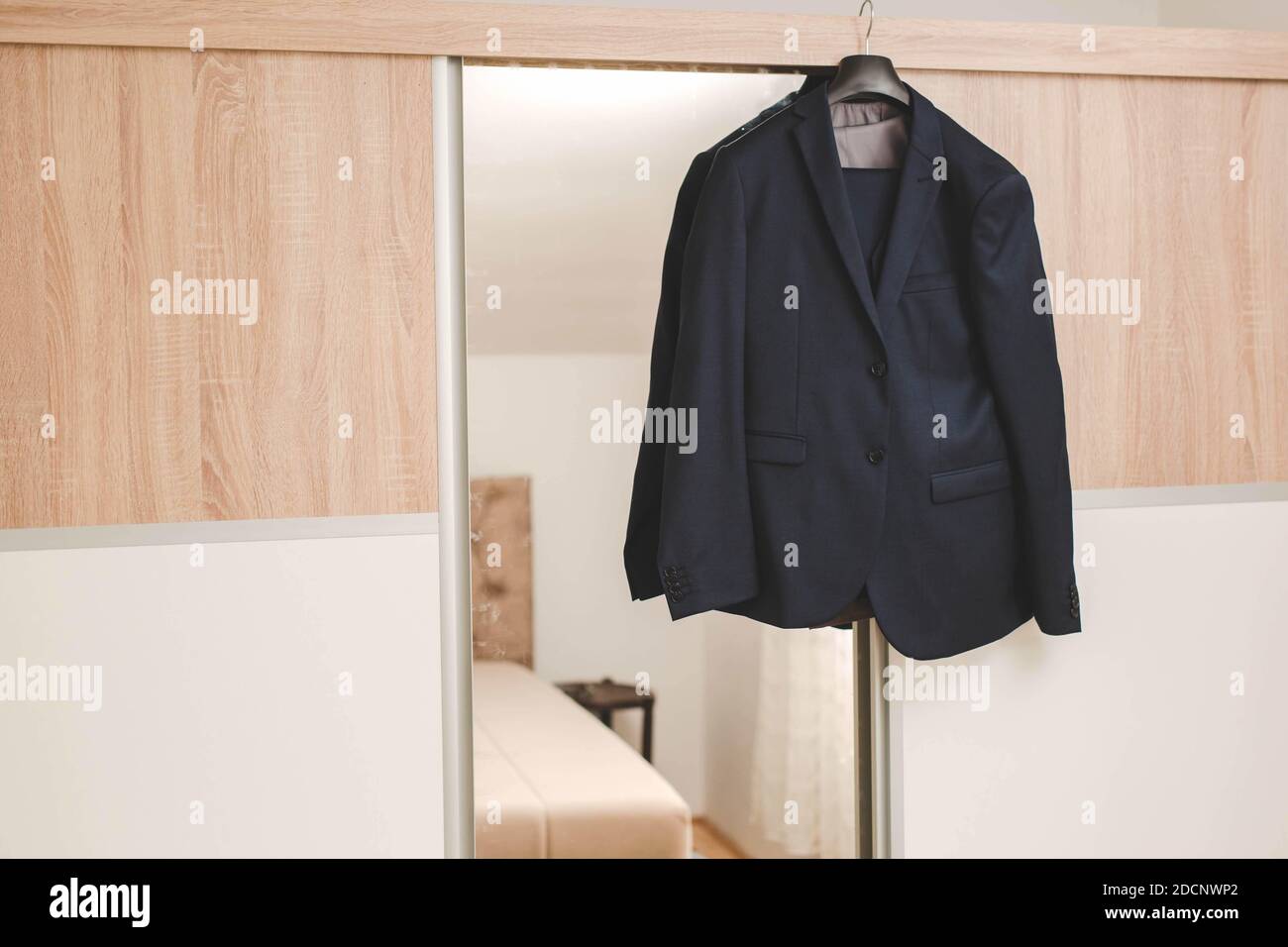 a black classic suit hung from a wardrobe Stock Photo - Alamy