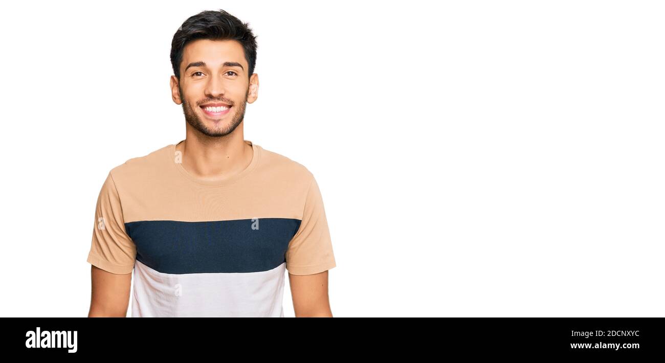 Young handsome man wearing casual clothes with a happy and cool smile ...