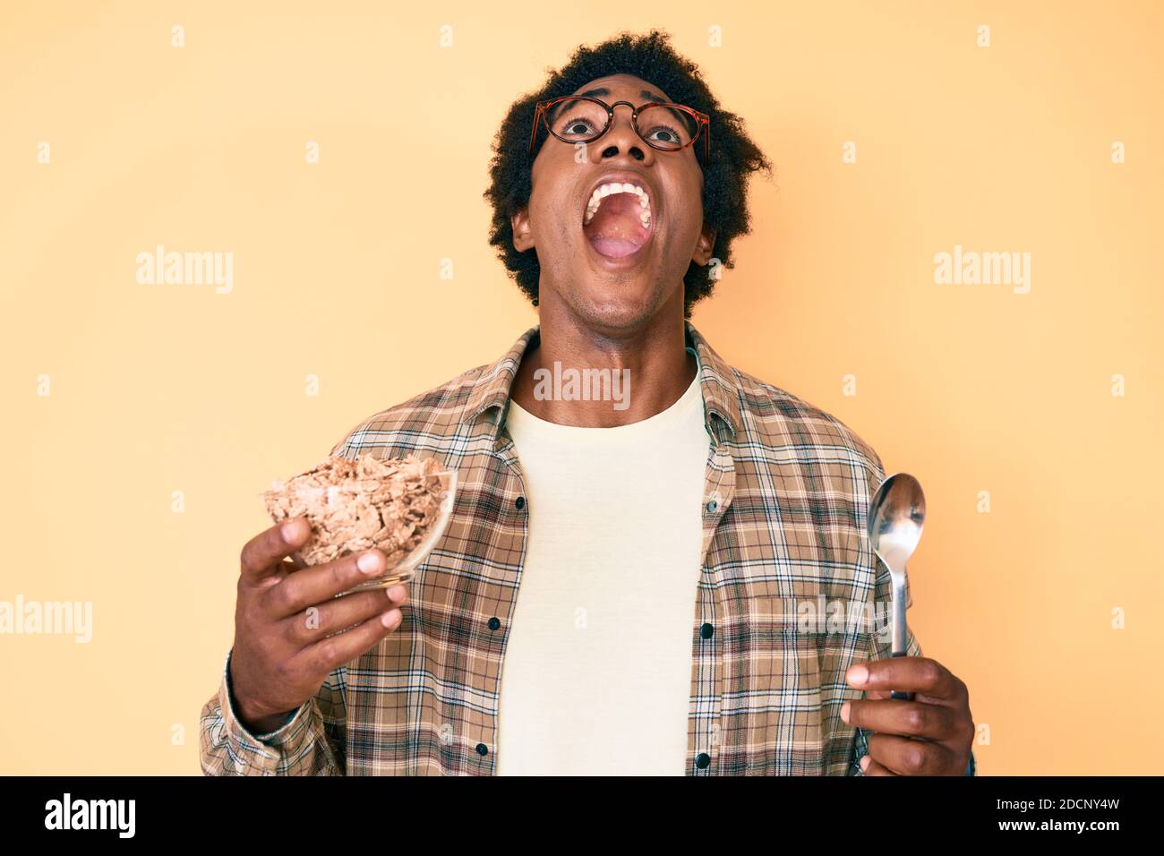 Handsome african american man with afro hair eating healthy whole grain ...