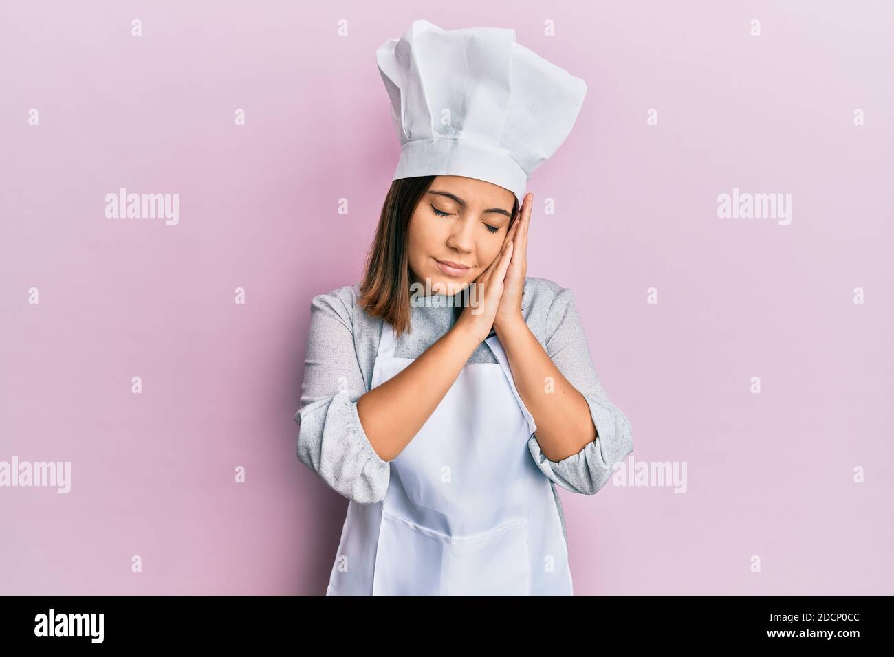 Young blonde woman wearing professional cook uniform and hat depressed ...
