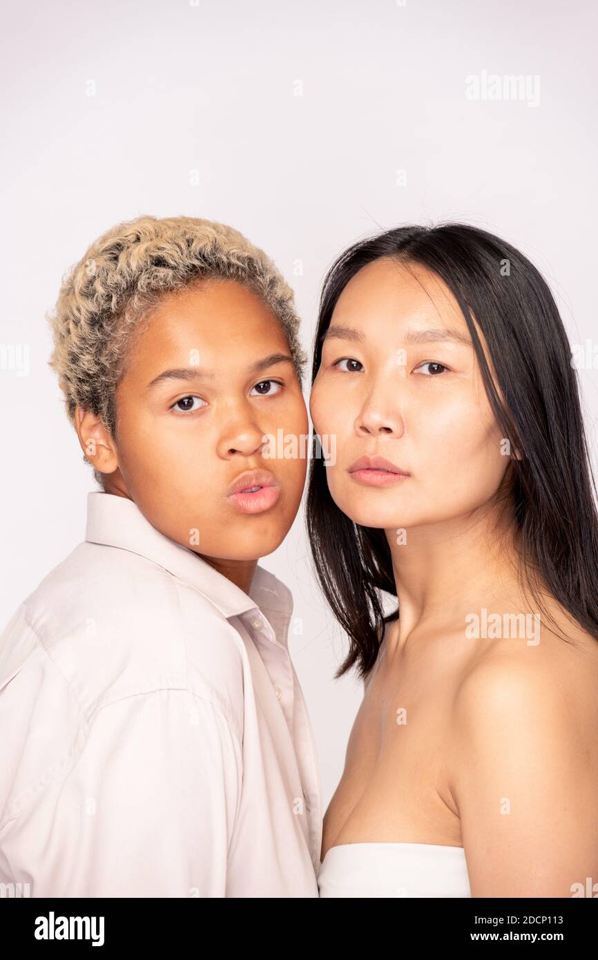 Faces of girls of African and Asian ethnicities standing close to one ...