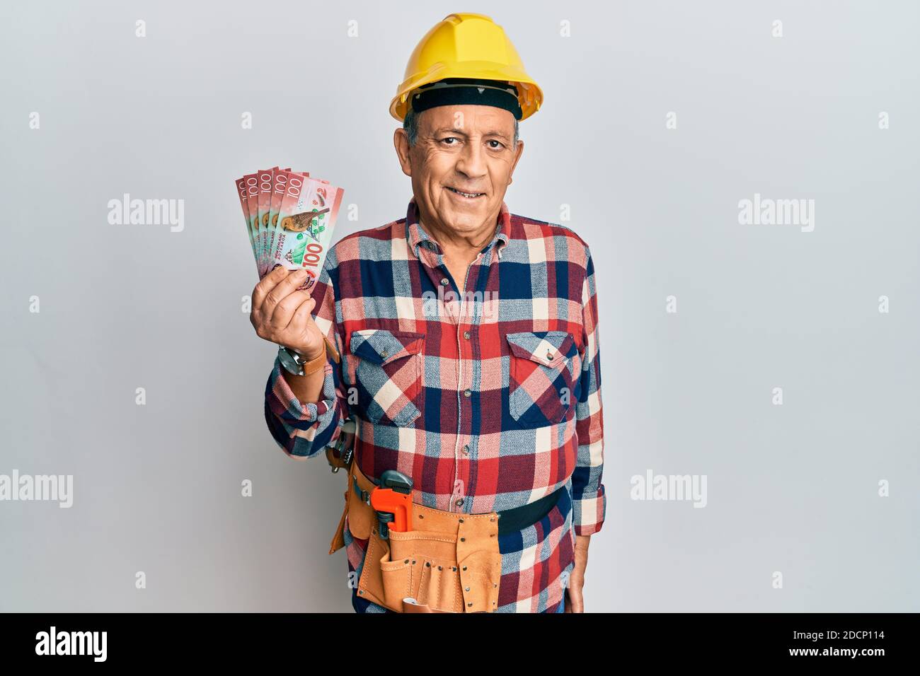 Handsome senior man with grey hair wearing handyman uniform and hardhat ...