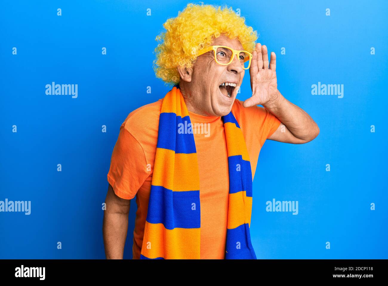 Handsome senior man with grey hair football hooligan wearing funny wig ...