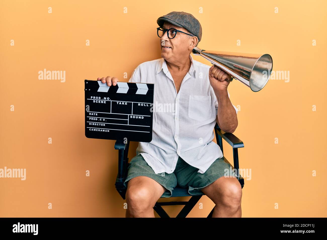 Handsome mature director man holding video film clapboard and louder ...