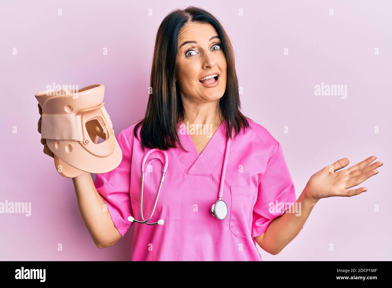 Middle age brunette doctor woman holding cervical neck collar ...
