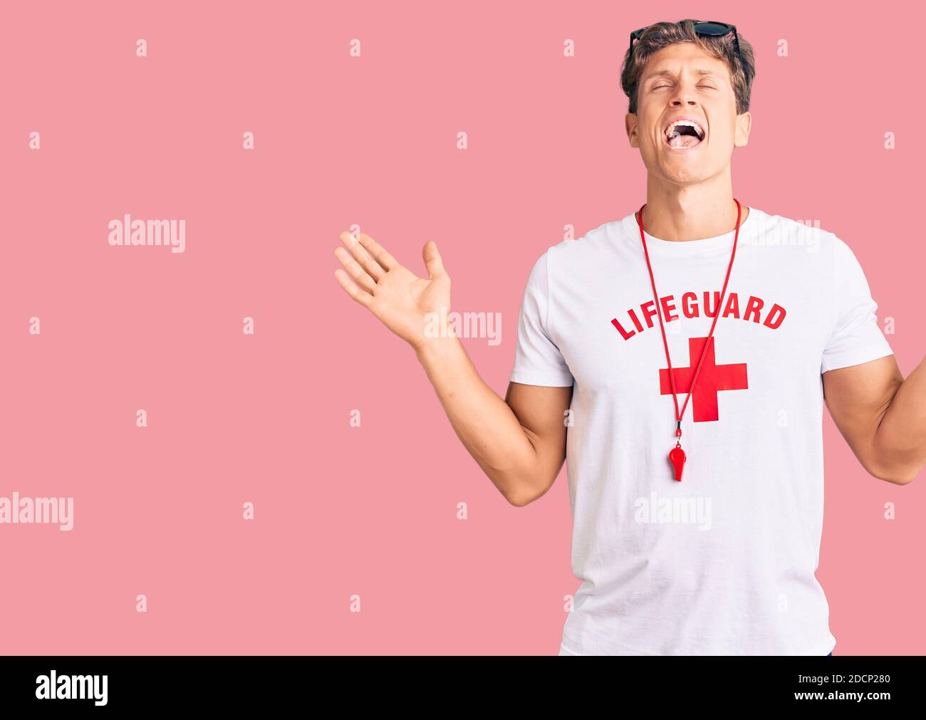 Young handsome man wearing lifeguard t shirt and whistle celebrating ...